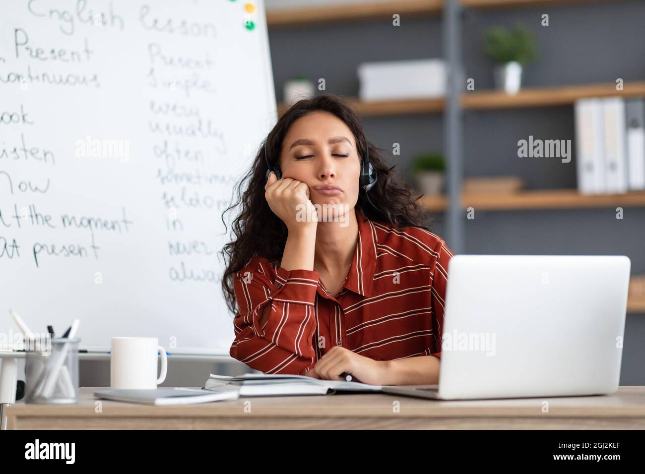 Too Much Work. Tired sleepy young woman in headset sitting at her desk ...
