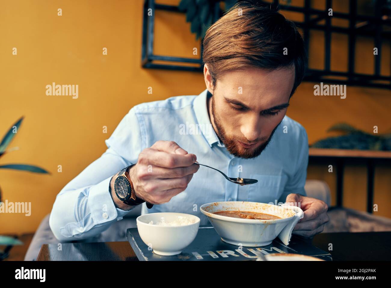 Man eating soup lunch snack in a restaurant Stock Photo - Alamy