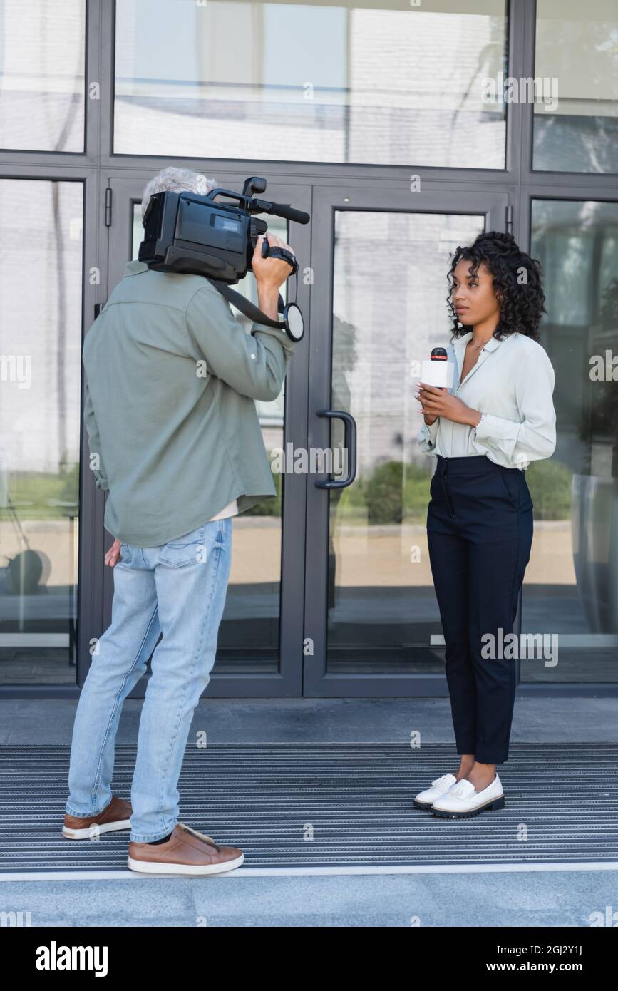 full length of african american journalist doing reportage near ...