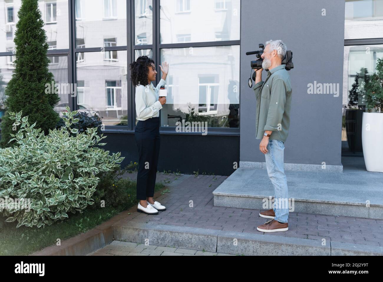 full length of happy african american journalist with microphone ...