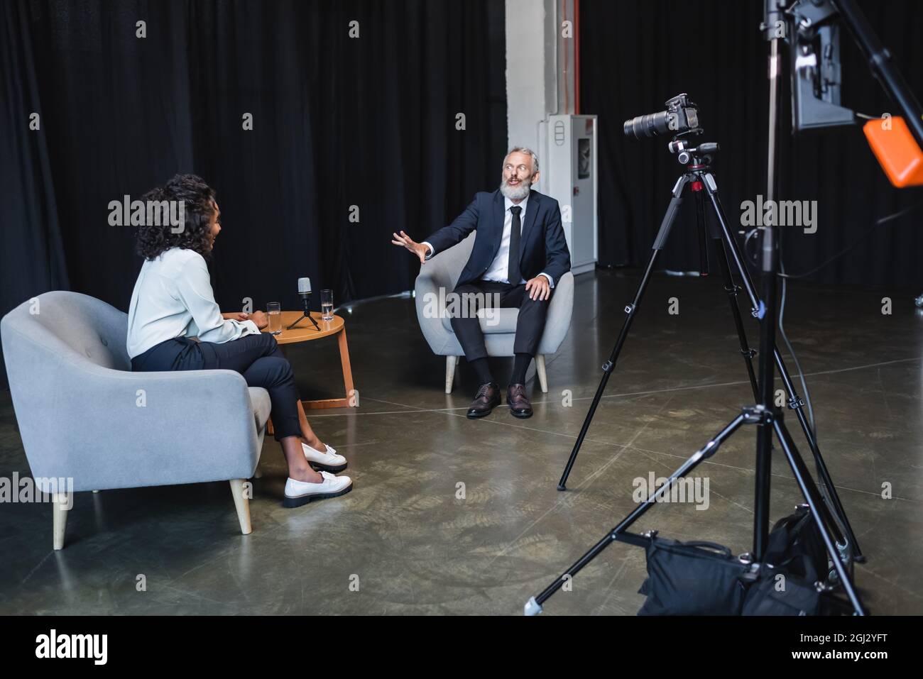 businessman gesturing while talking with curly african american ...