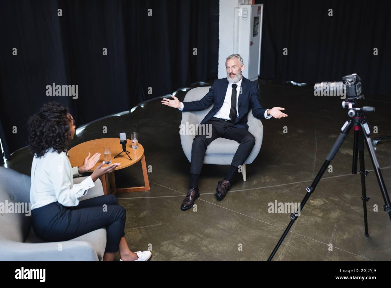 high angle view of businessman in suit gesturing during interview with ...