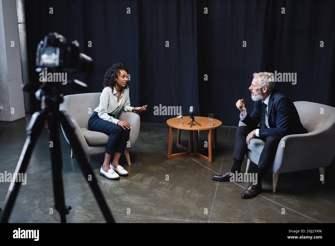 african american journalist talking with guest in interview studio ...