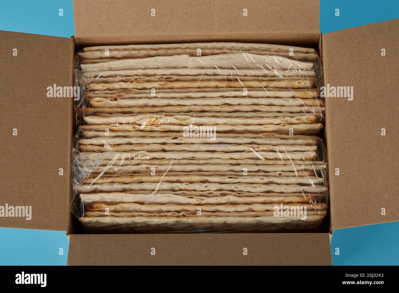 Traditional Jewish matzah lies in a cardboard box packed in a bag. The ...