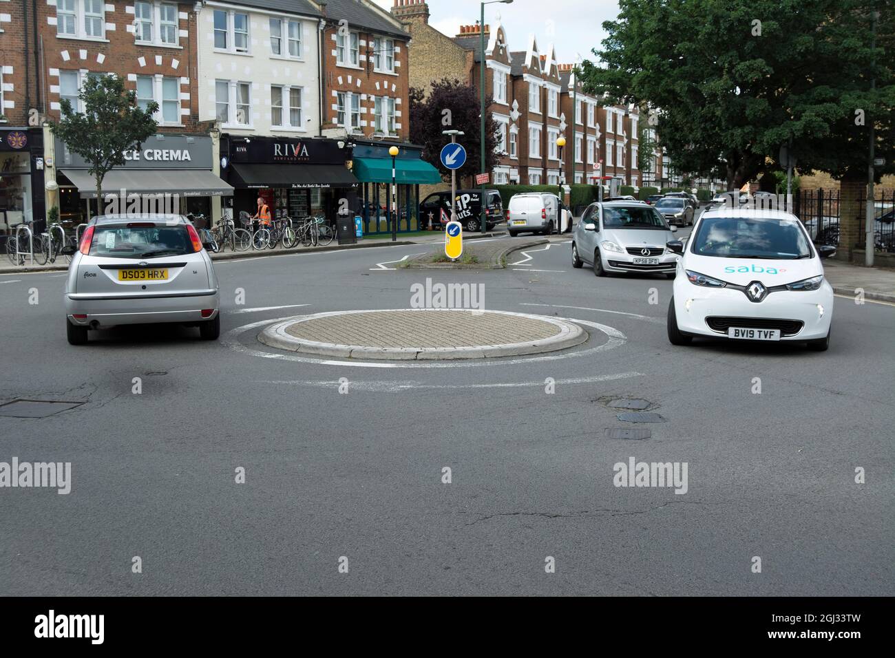 cars negotiate a mini roundabout with a raised centre in mortlake ...