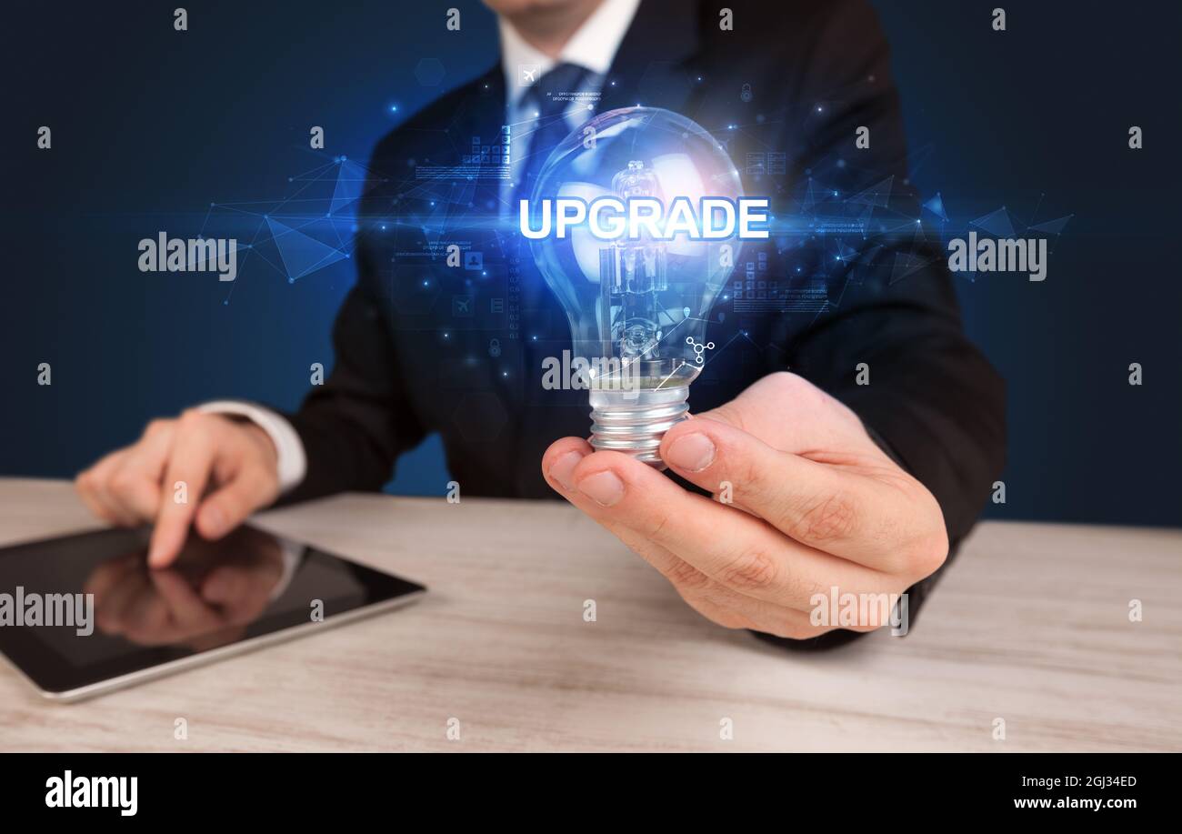 Businessman holding a light bulb Stock Photo - Alamy