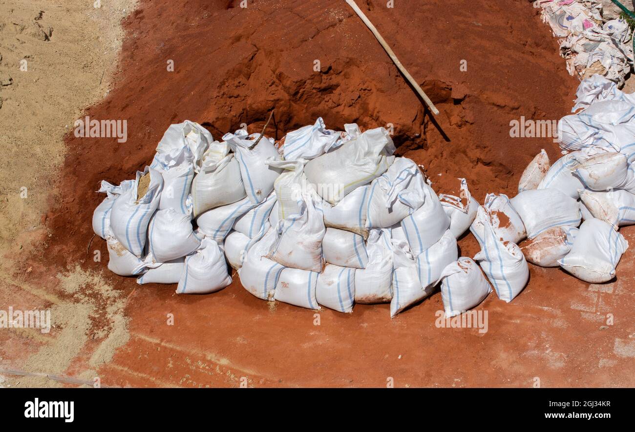 Shot of a bunch of sacks with some stuff laying on red sand Stock Photo ...