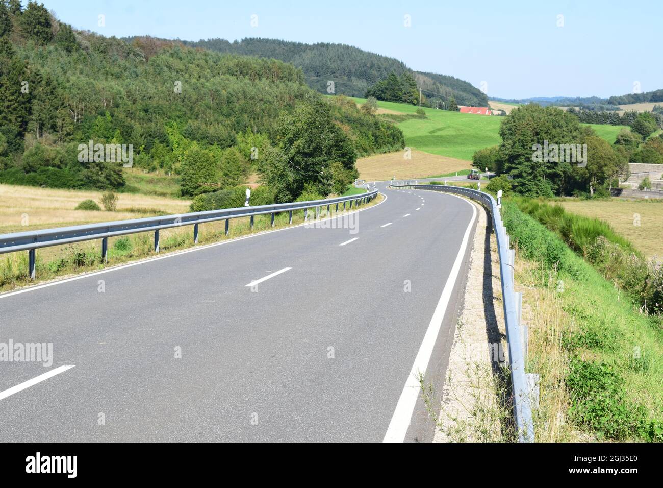 wide road in the Eifel, with weird curves Stock Photo - Alamy