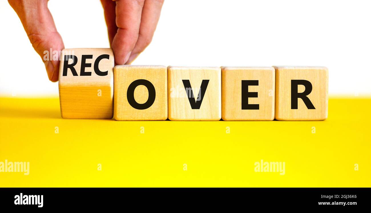 Time to recover symbol. Businessman turns a wooden cube and changes the ...