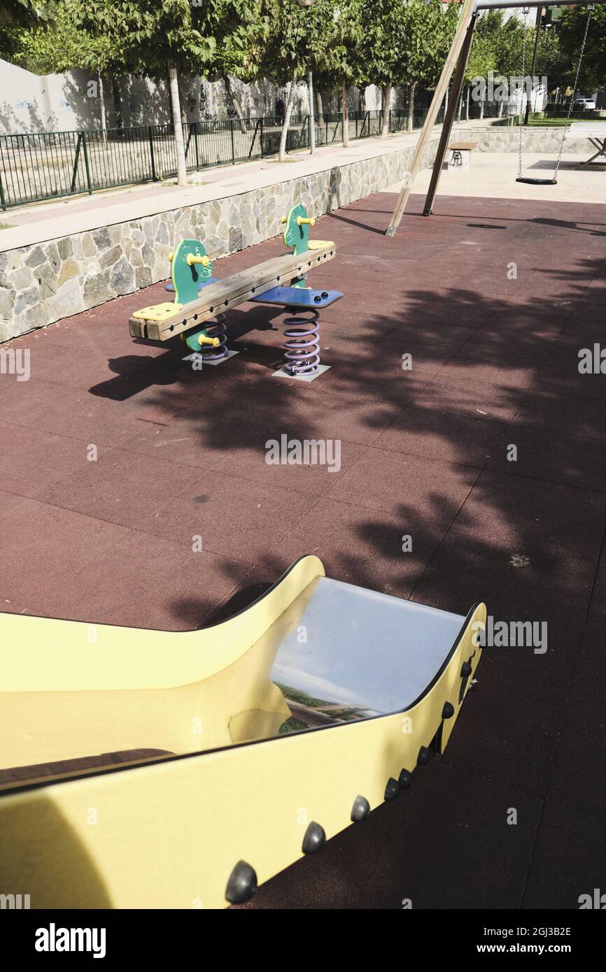 Shot of a yellow slide and swing balancer in a playground under the ...