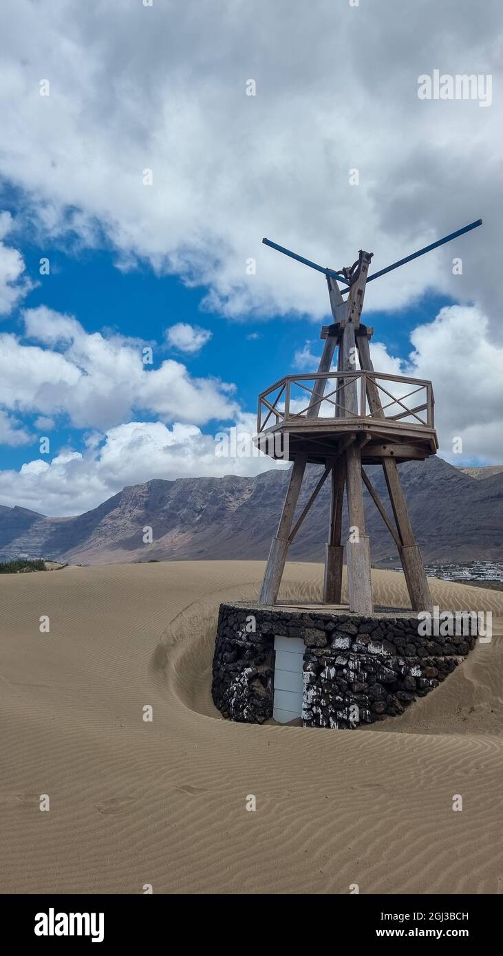 Vertical shot of a wooden tower in the sand on the beach with beautiful ...