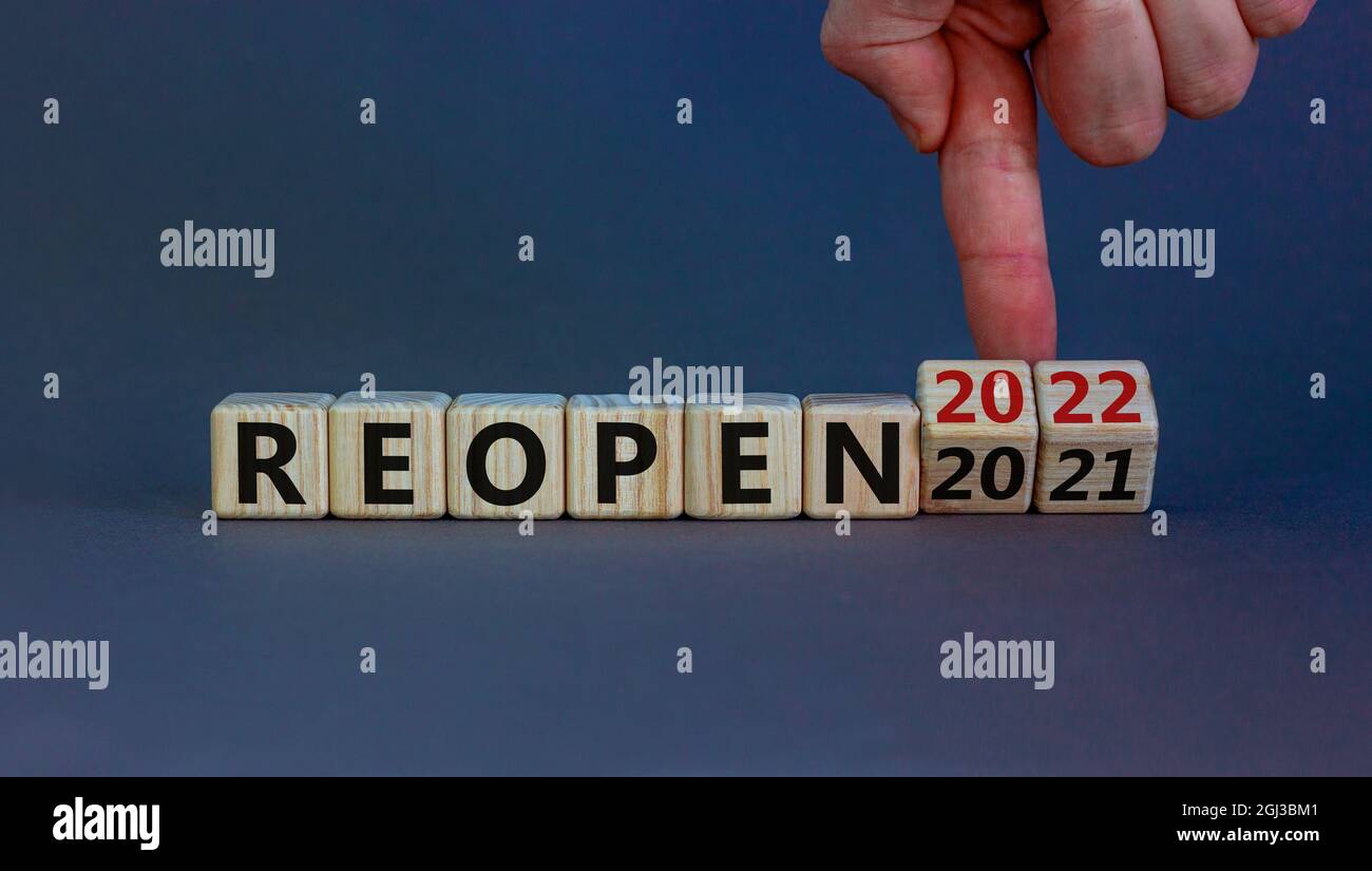 2022 reopen new year symbol. Businessman turns wooden cubes and changes ...