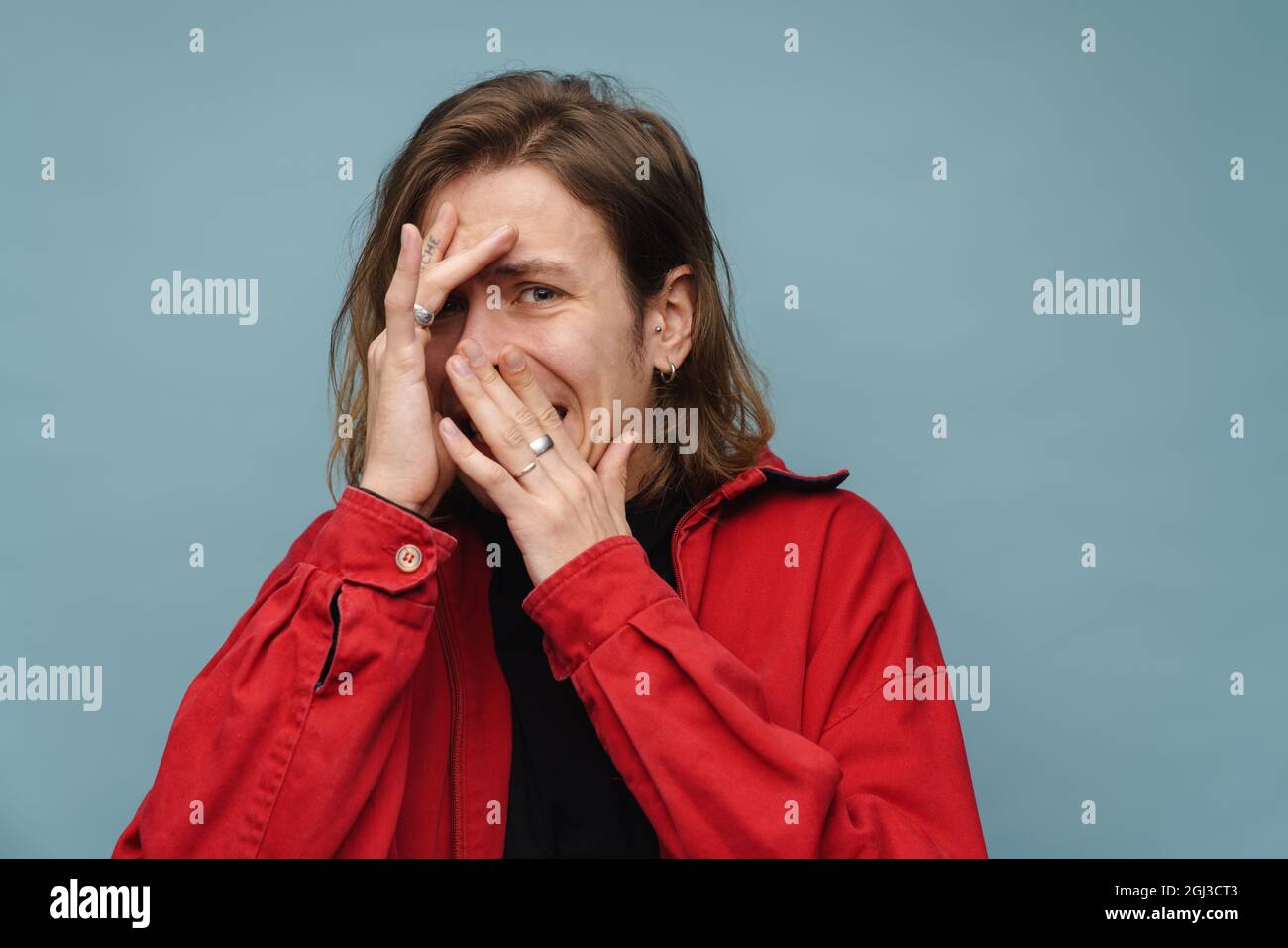 Young white scared man looking at camera and covering his face isolated ...