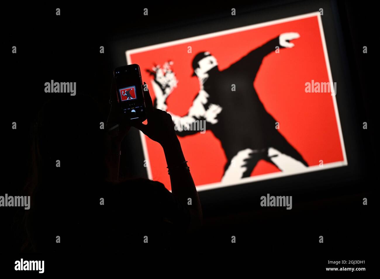 A guest uses a cell phone to photograph "Flower Thrower" by artist ...