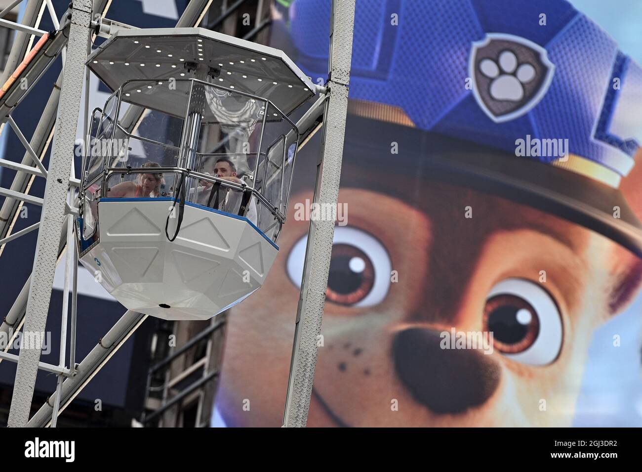 People are seen riding a ferris wheel setup along Broadway in Times ...
