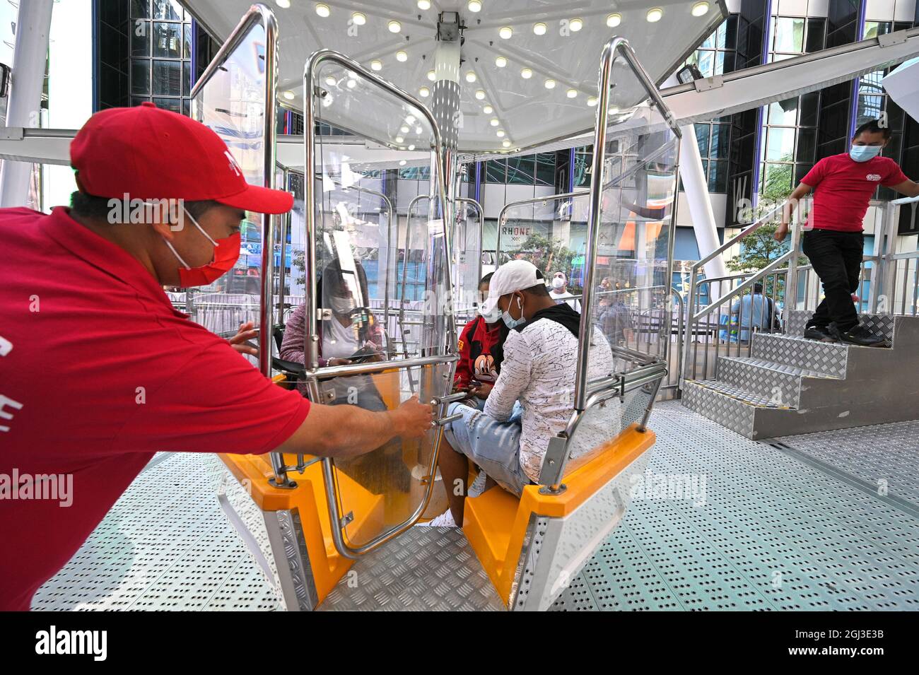 People are seen inside a gondola cabin as they prepare to ride a ferris ...