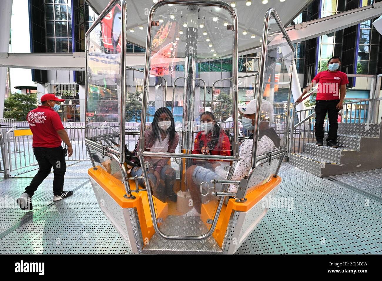 People are seen inside a gondola cabin as they prepare to ride a ferris ...