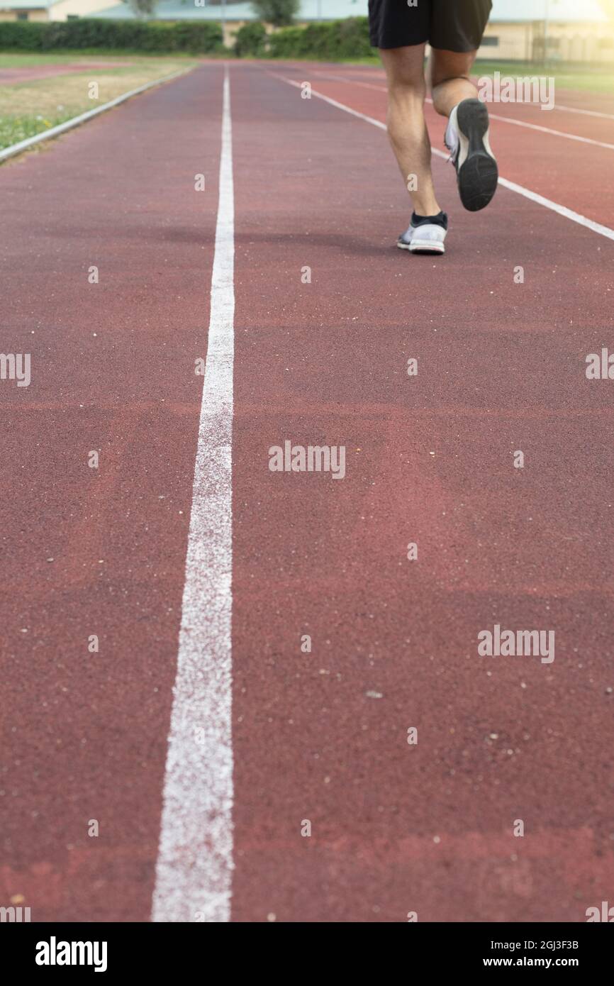 detail of an athlete's feet running on a street of an athletics track ...
