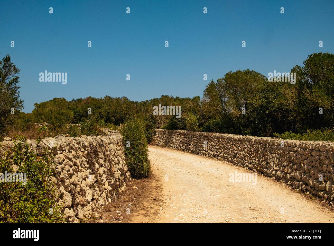 spanish unpaved street in the spanish countryside with stones sides. an ...