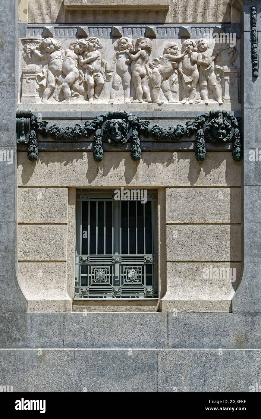 Window with a figured lattice and a bas-relief on top of the facade of ...