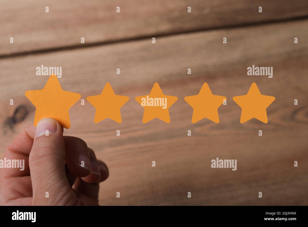 Top view of a man's hand holding a yellow star with 2D yellow stars ...