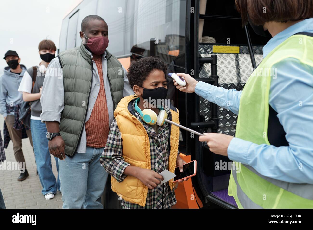 Bus supervisor or conductor using infrared thermometer while checking ...