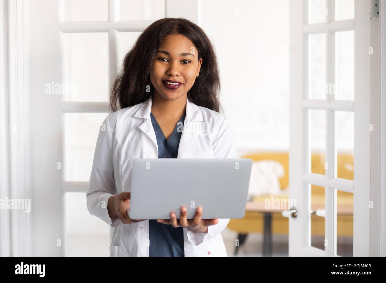 black skinned female medic smiling standing on a white background with ...
