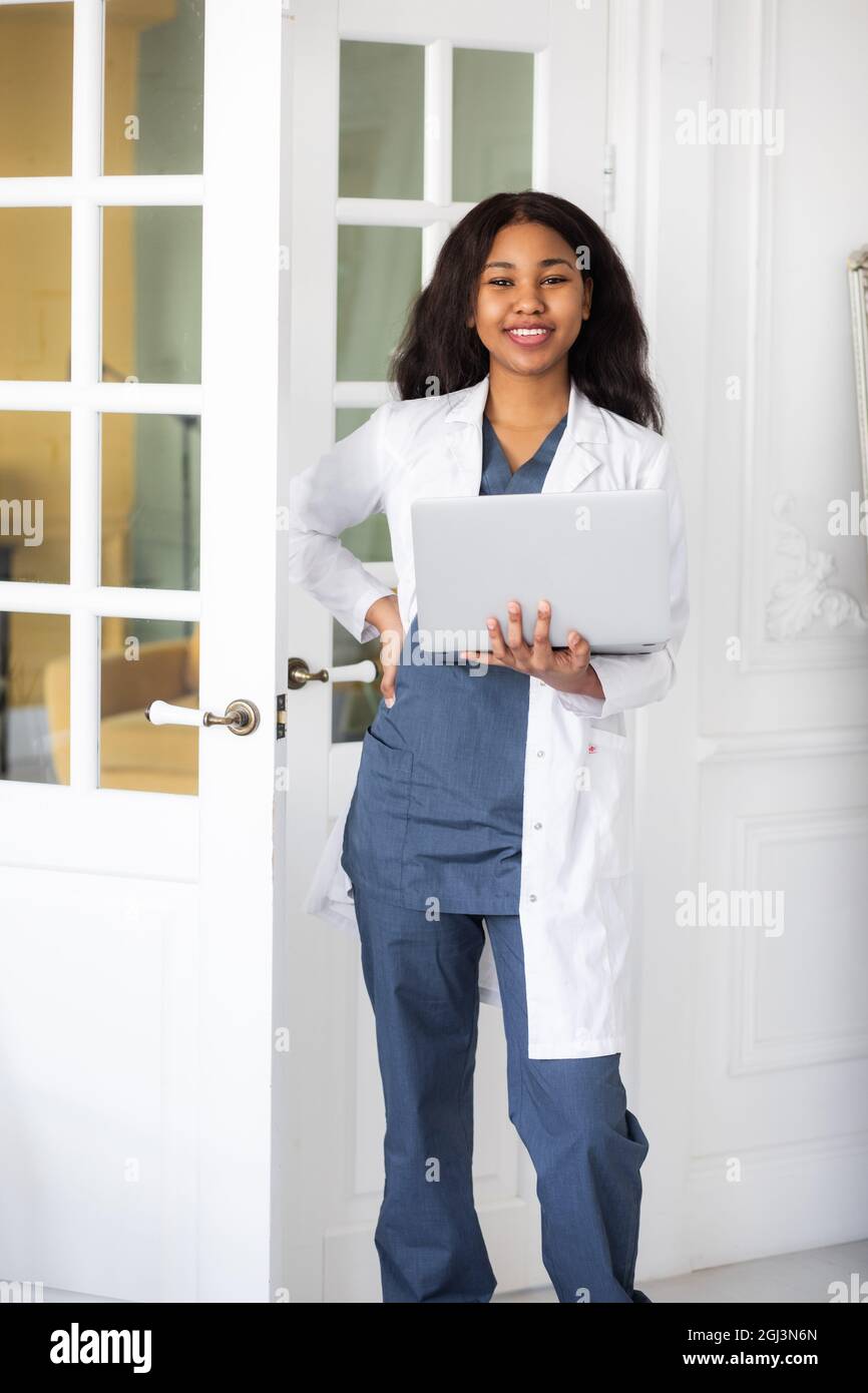 black skinned female medic smiling standing on a white background with ...