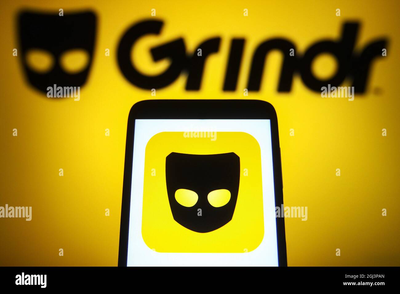 In this photo illustration a Grindr logo is seen on a smartphone and a ...