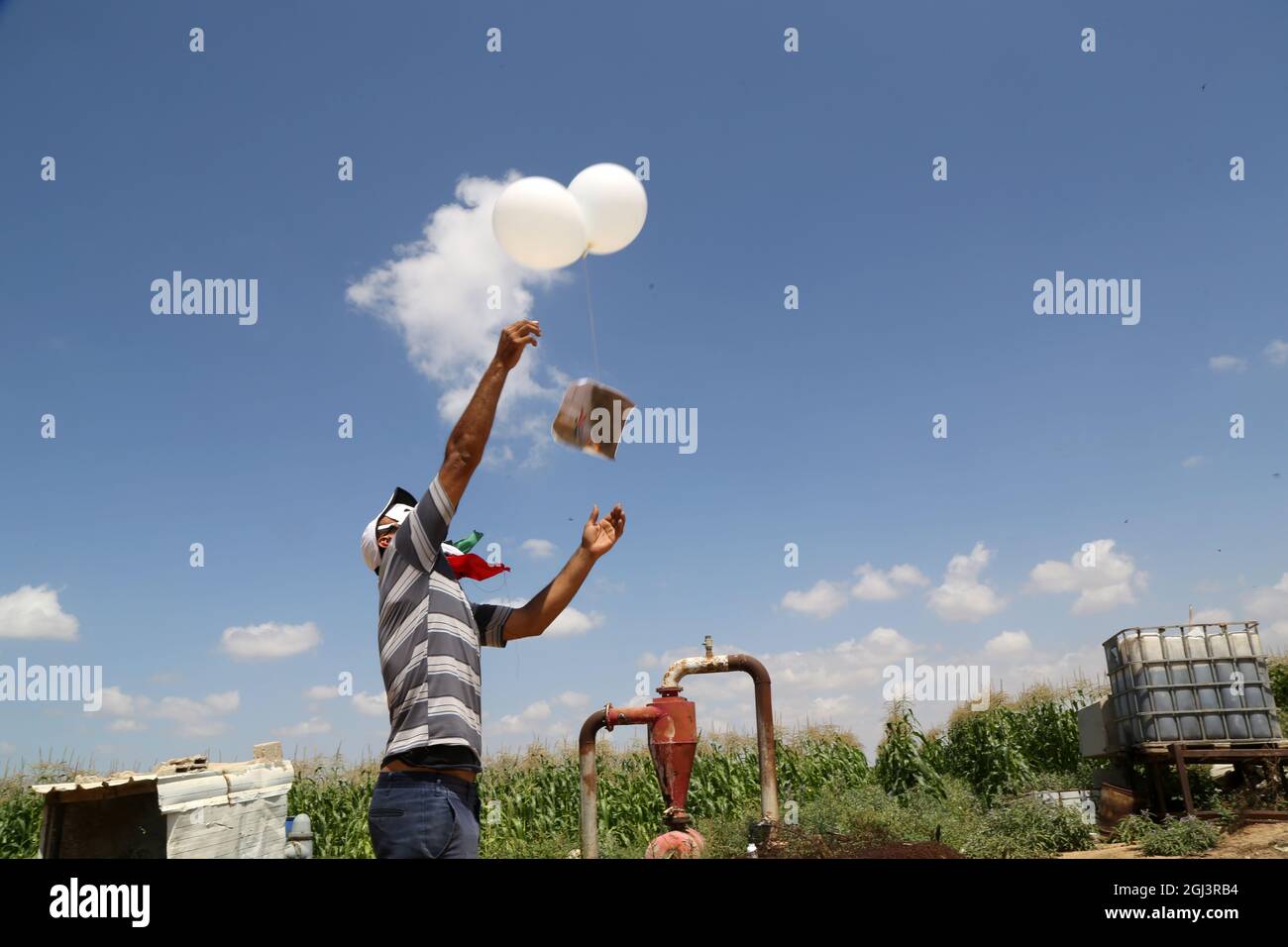 Masked Palestinian launches balloons towards Israel.Palestinian ...