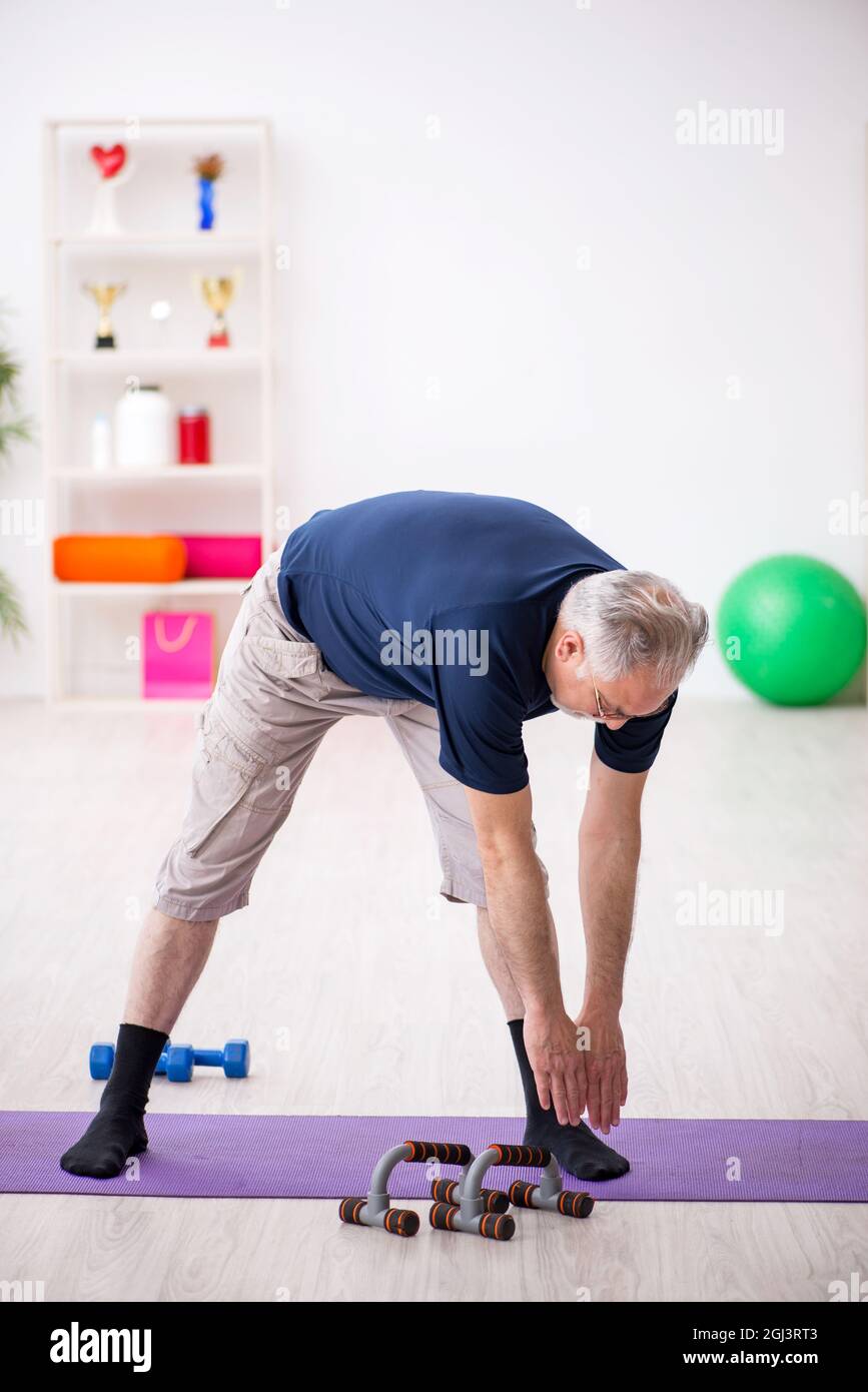 Old man doing sport exercises at home Stock Photo - Alamy