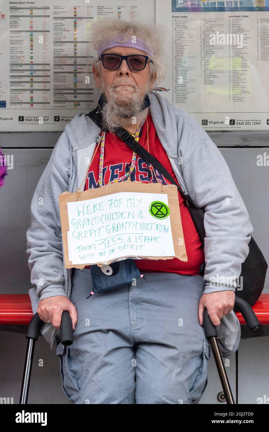 An activist wears a sign around his neck saying Here for my ...