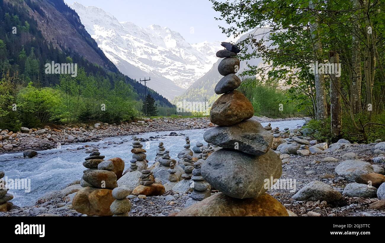 Stacked towers of rocks next to a stream at the end of the ...