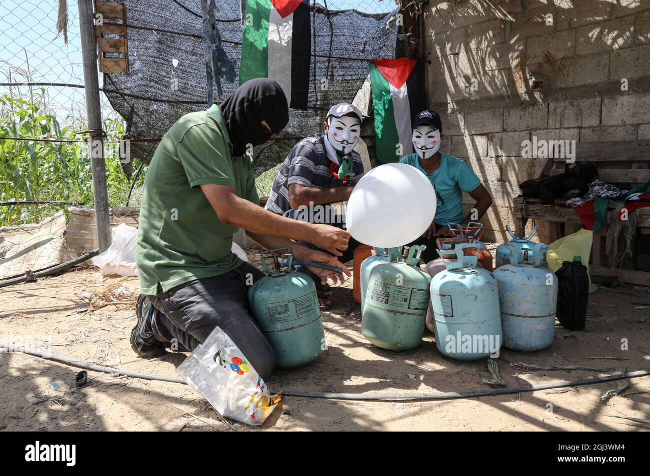 Masked Palestinians fill balloons to launch it towards Israel ...