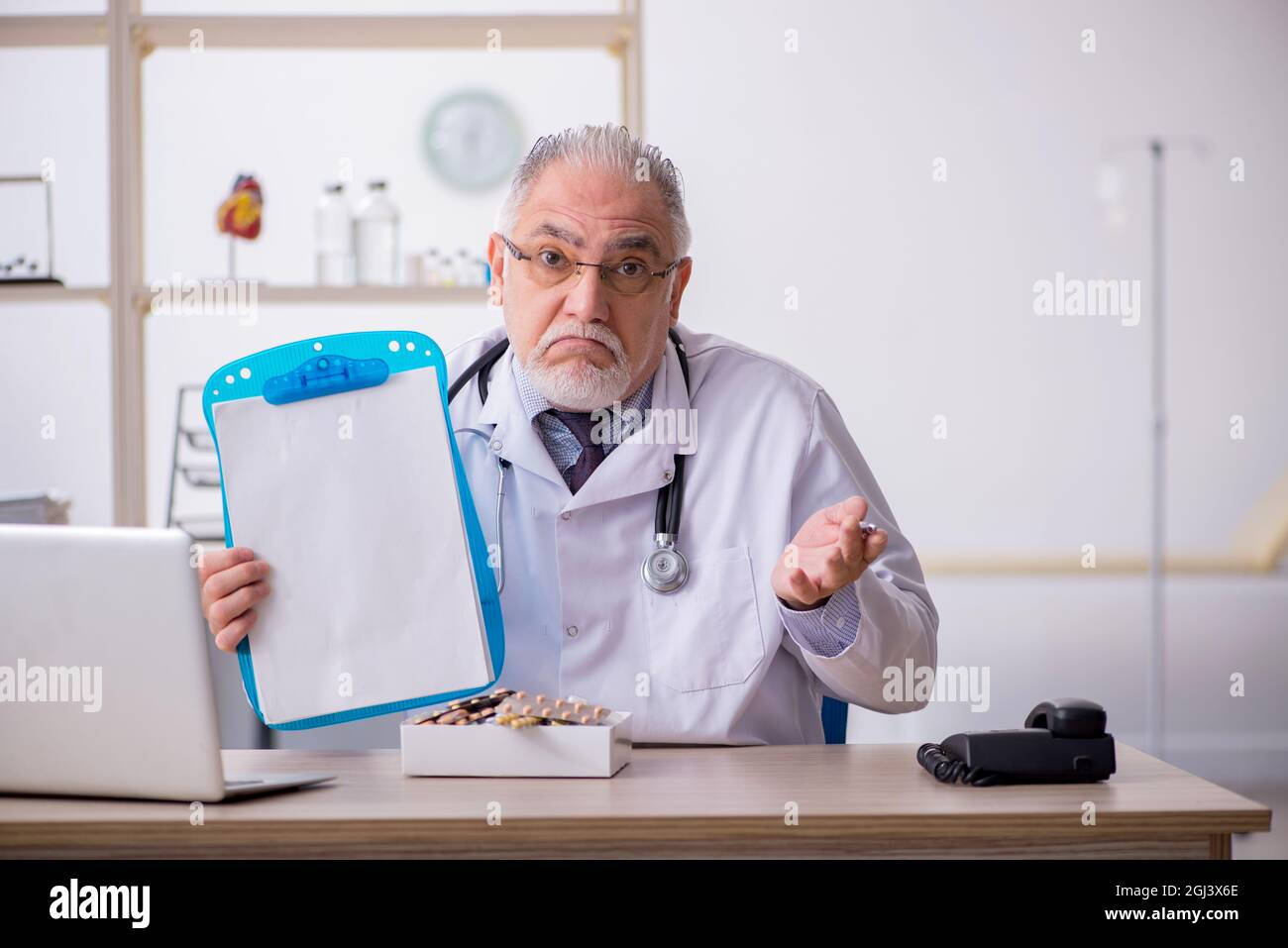 Old male doctor working at the hospital Stock Photo - Alamy