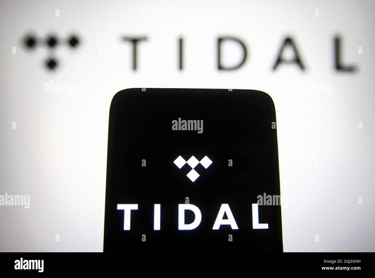In this photo illustration a Tidal logo is seen on a smartphone and a ...