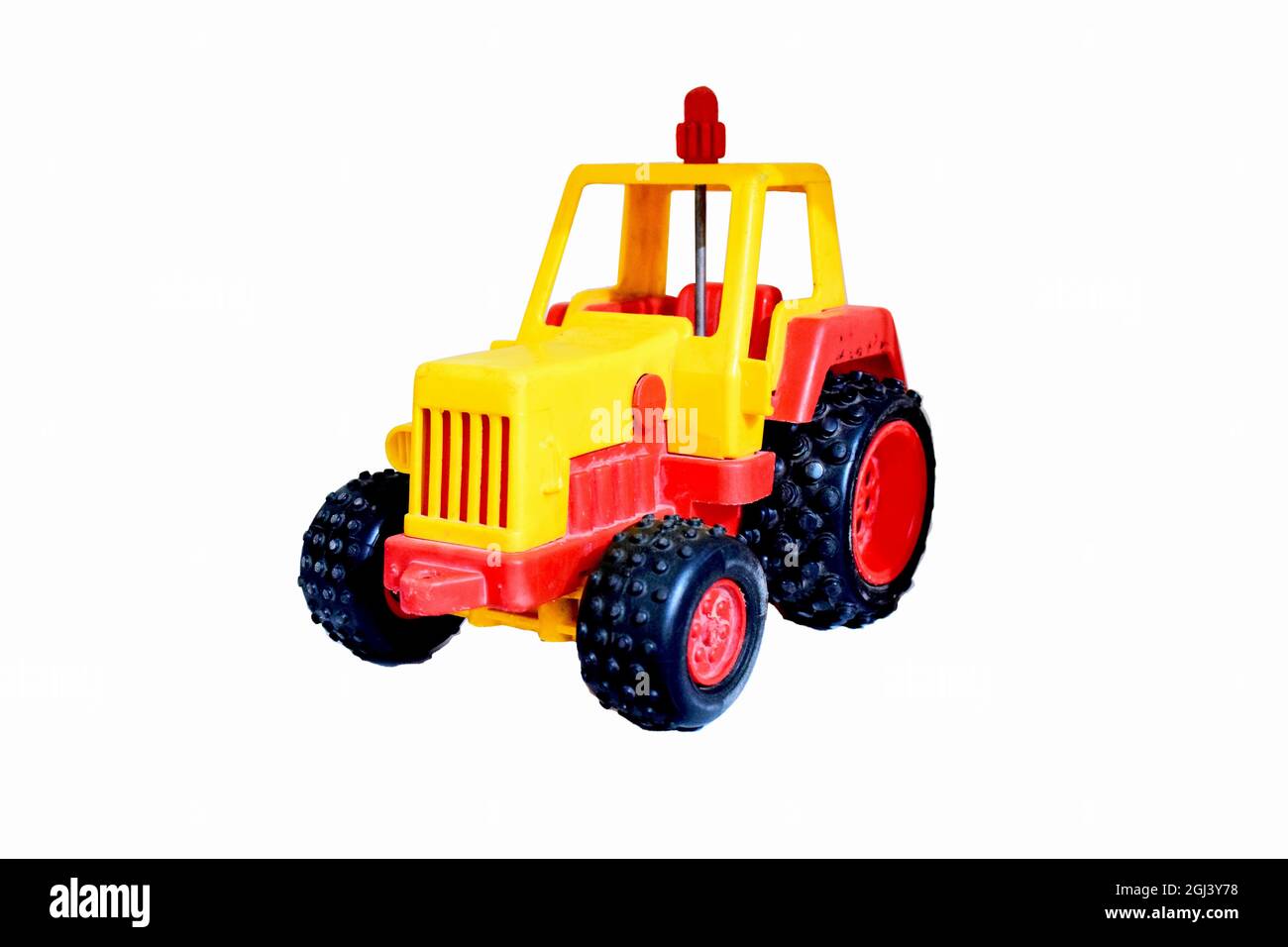 Closeup of a colorful plastic toy tractor isolated on a white ...