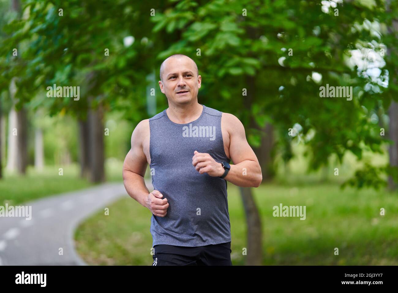 Athletic man long distance runner training in the park alleys Stock ...