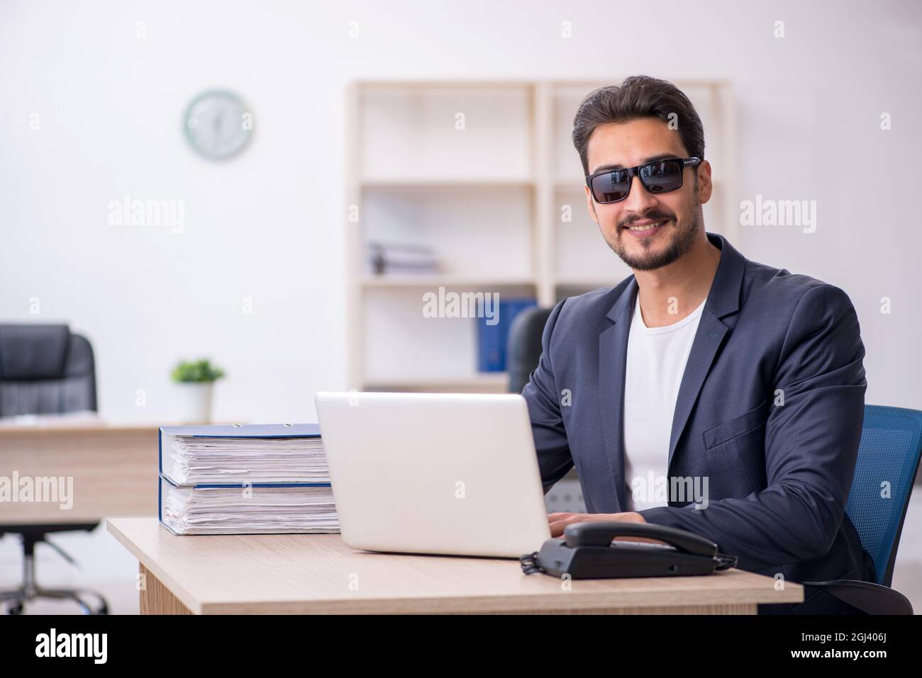 Young male employee working in the office Stock Photo - Alamy