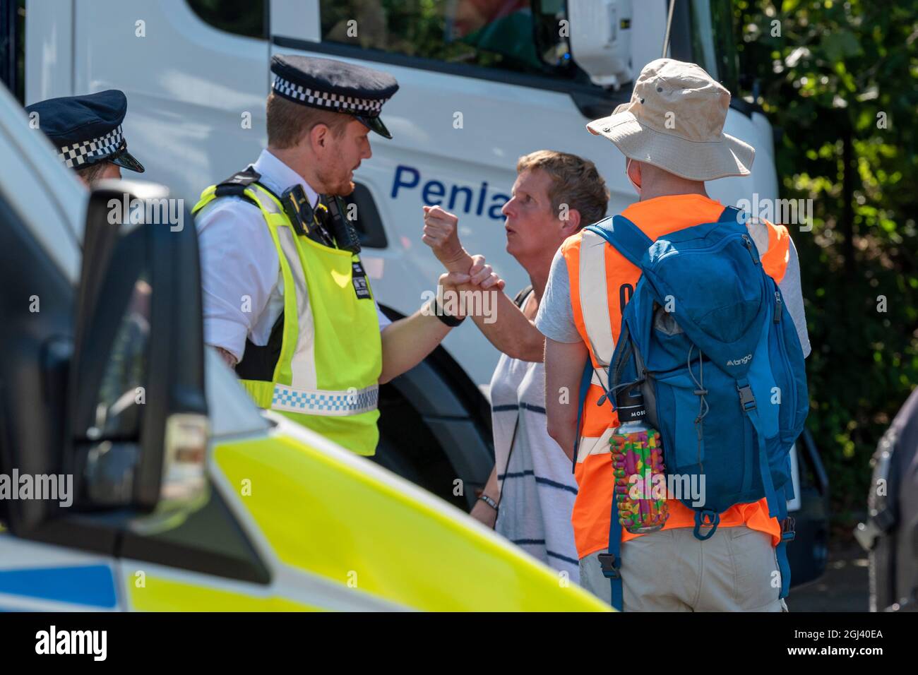 A police officer grabs a protester's hand, trying to stop cars as ...