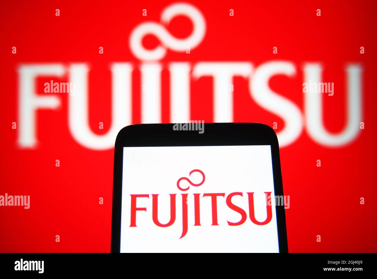 In this photo illustration a Fujitsu Limited logo is seen on a ...