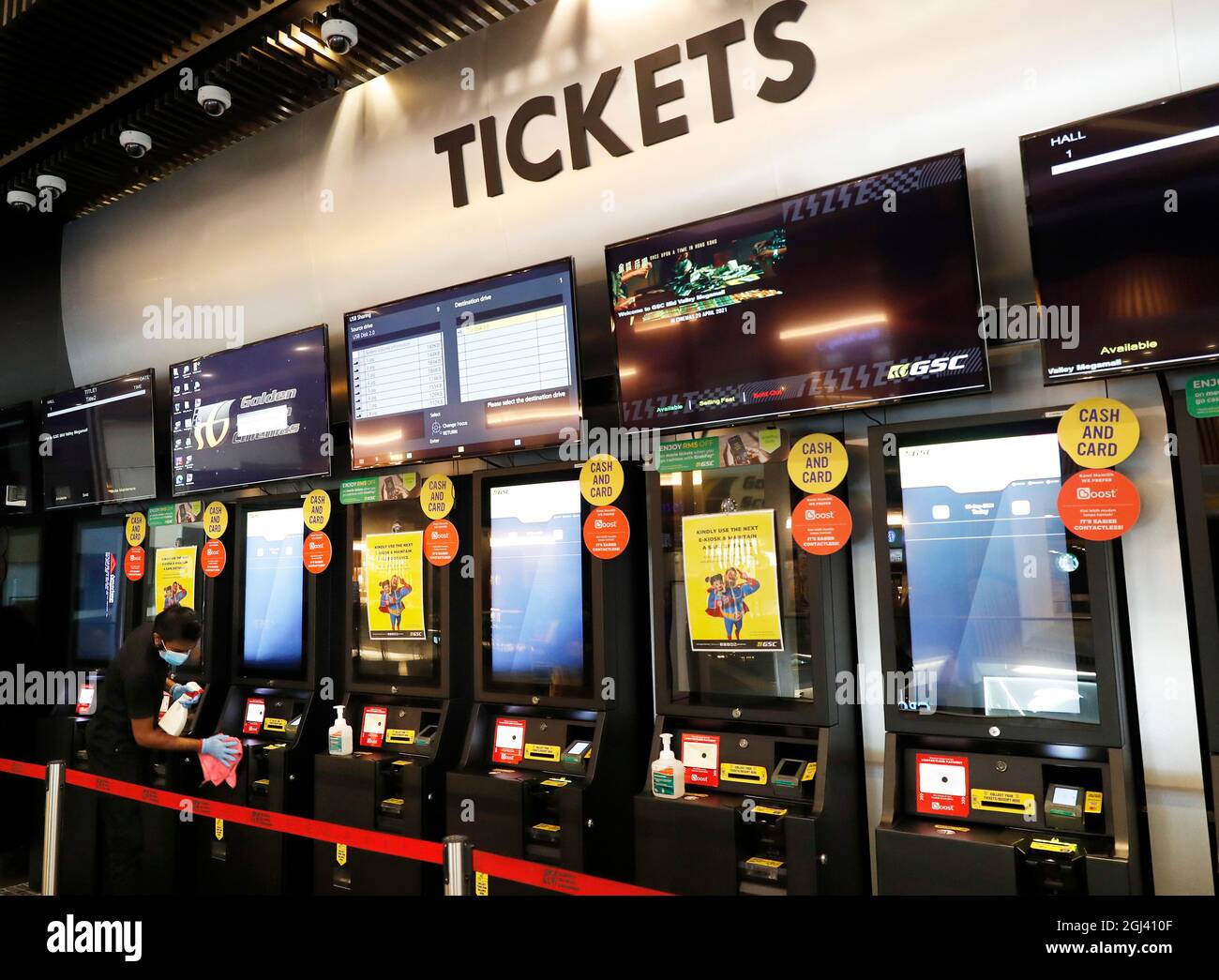 A cinema staff seen sanitizing the ticketing machine during the ...