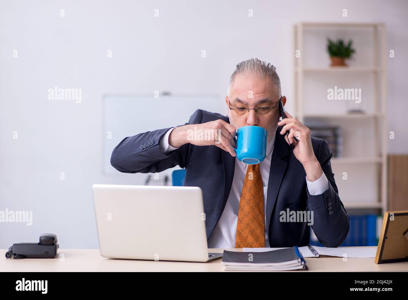 Old businessman employee drinking coffee during break Stock Photo - Alamy