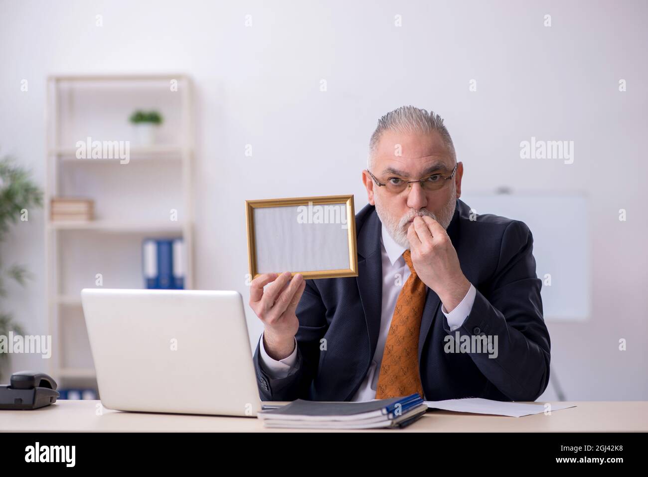 Old businessman employee missing his wife at workplace Stock Photo - Alamy