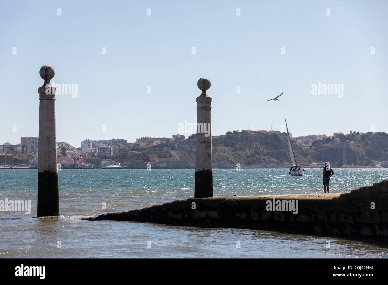 A man is seen relaxing at the Cais das Colunas pier, overlooking the ...