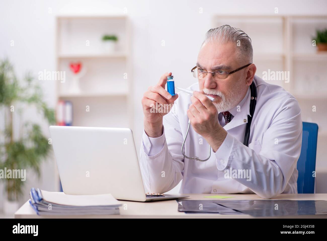 Old doctor working in the clinic Stock Photo - Alamy