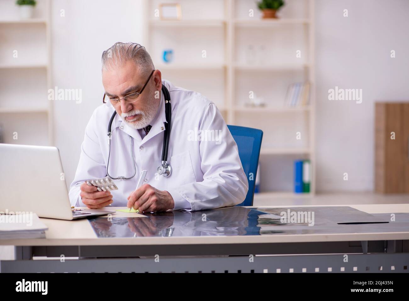 Old doctor working in the clinic Stock Photo - Alamy