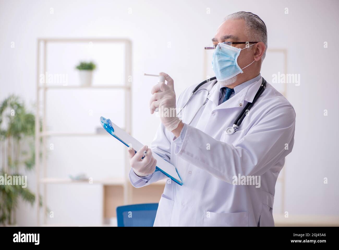 Old doctor working in the clinic Stock Photo - Alamy