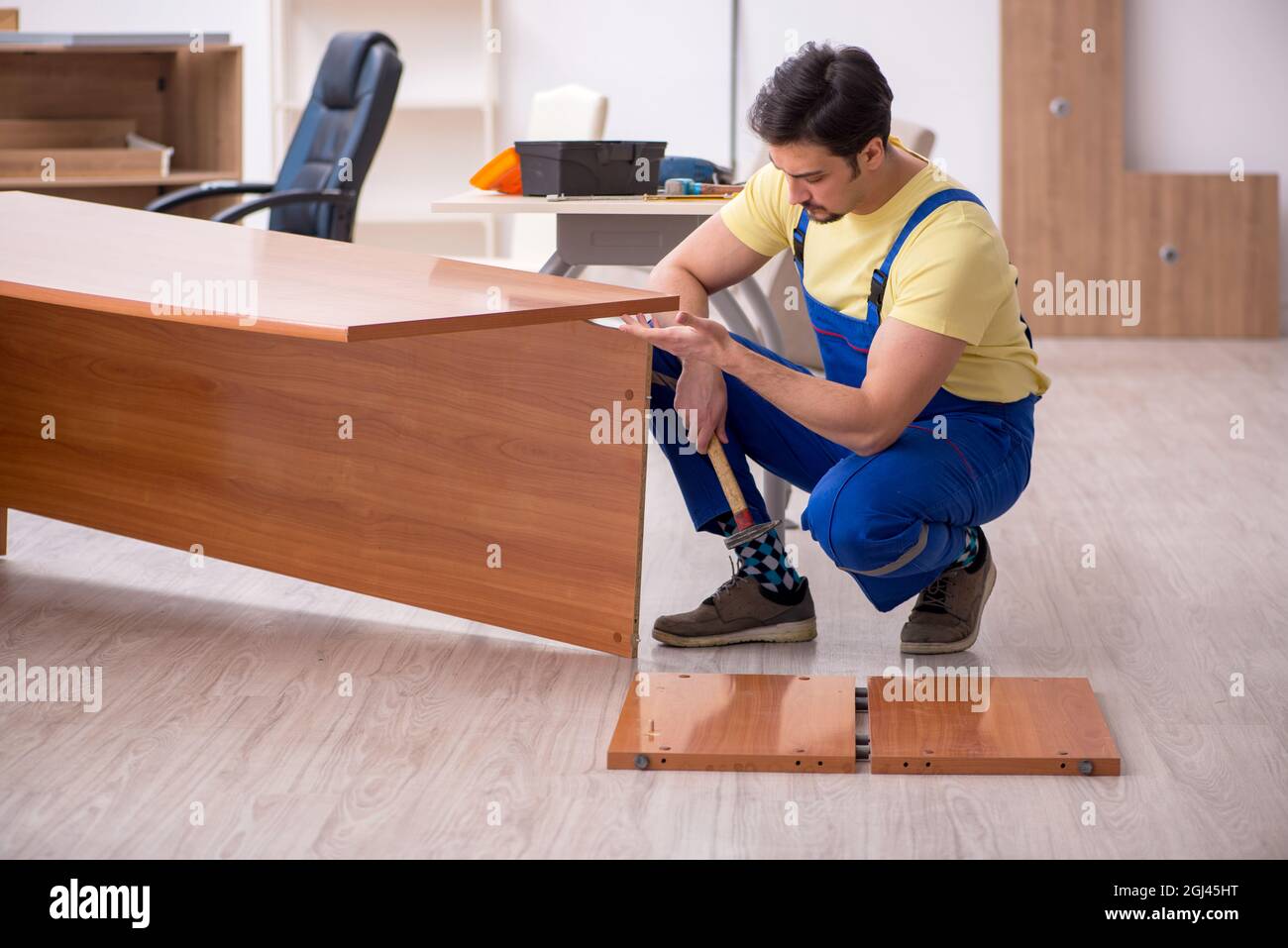 Young handyman repairing desk hi-res stock photography and images - Alamy