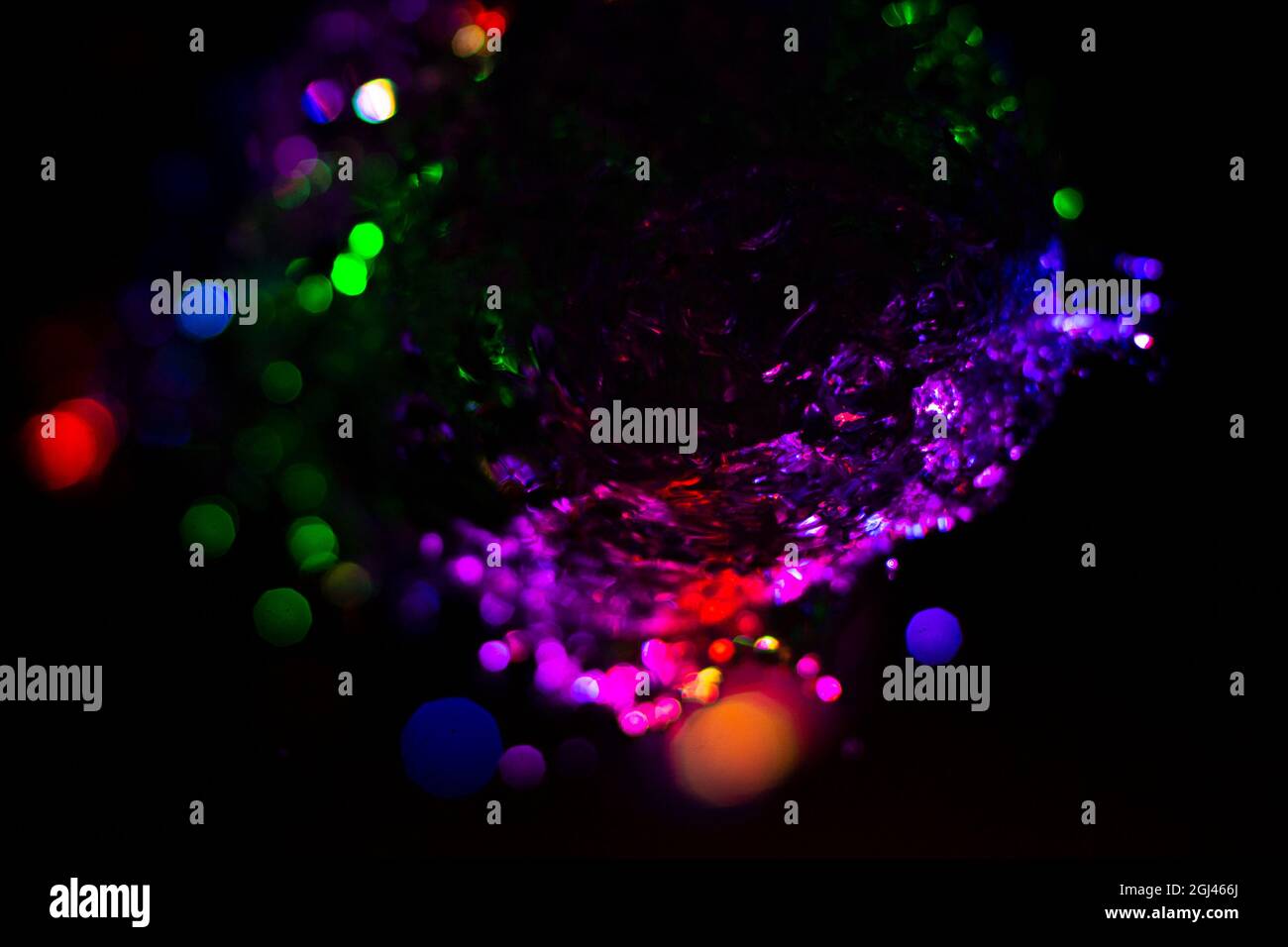 Colored water texture. Splashes of water lit in different colors. Close ...